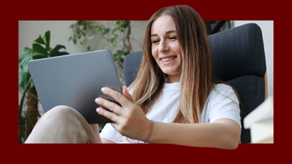 Jovem sentada aproveitando a leitura em seu tablet